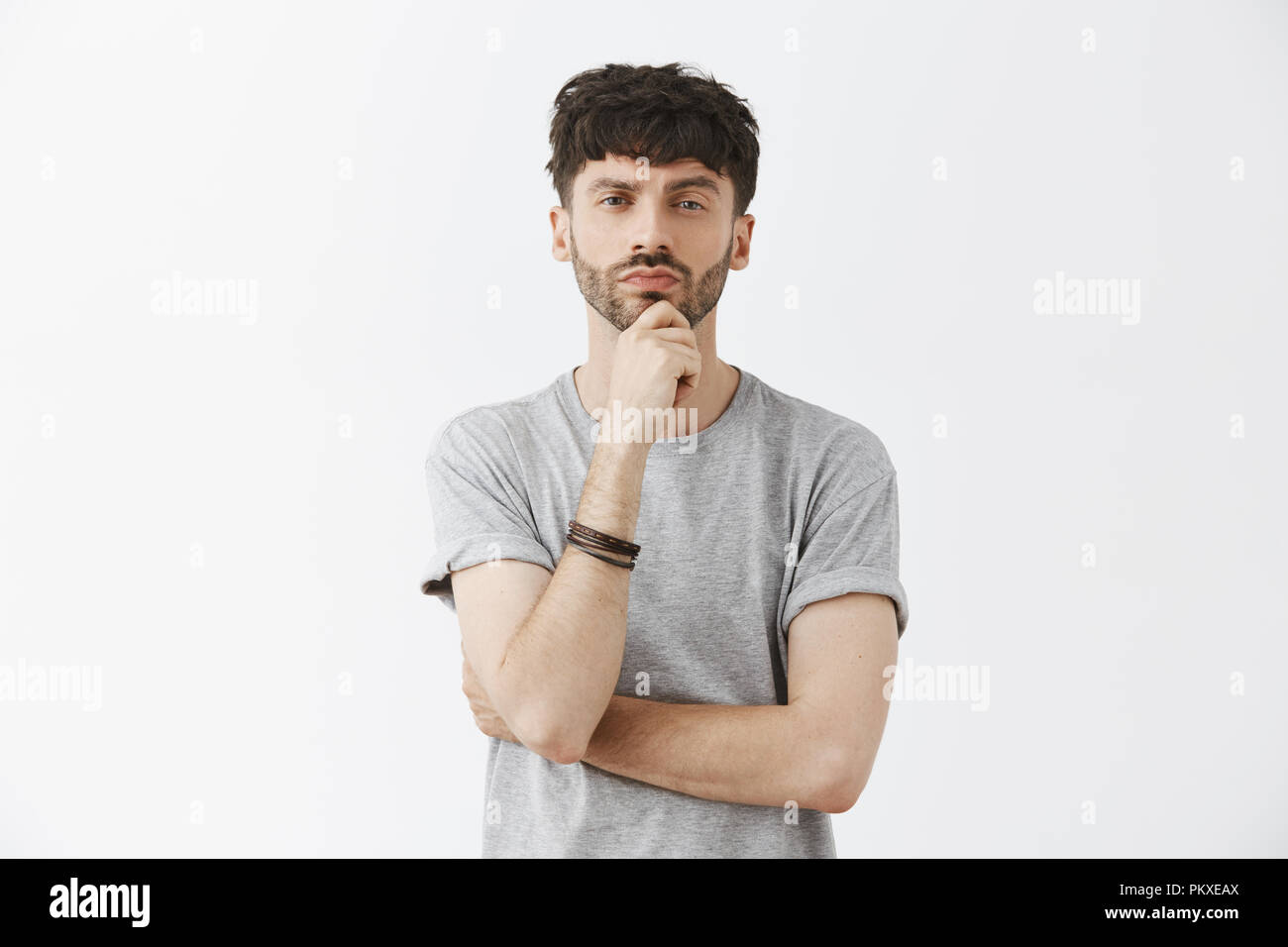 Waist-up shot of good-looking thoughtful male genius with dark hair and ...