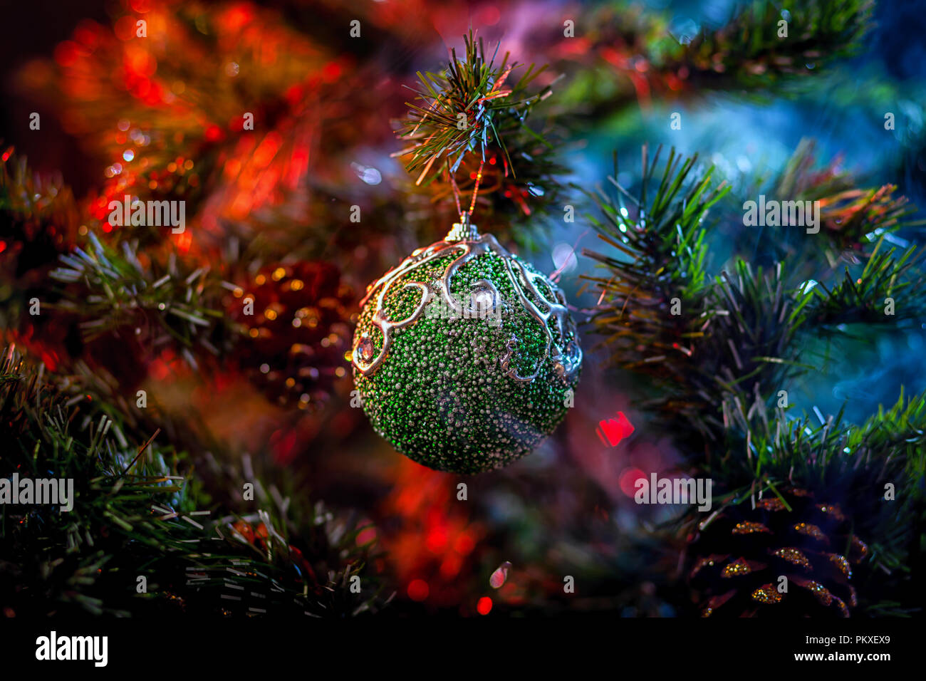 Green shiny decoration Christmas balls in colored purple-red smoke, on ...