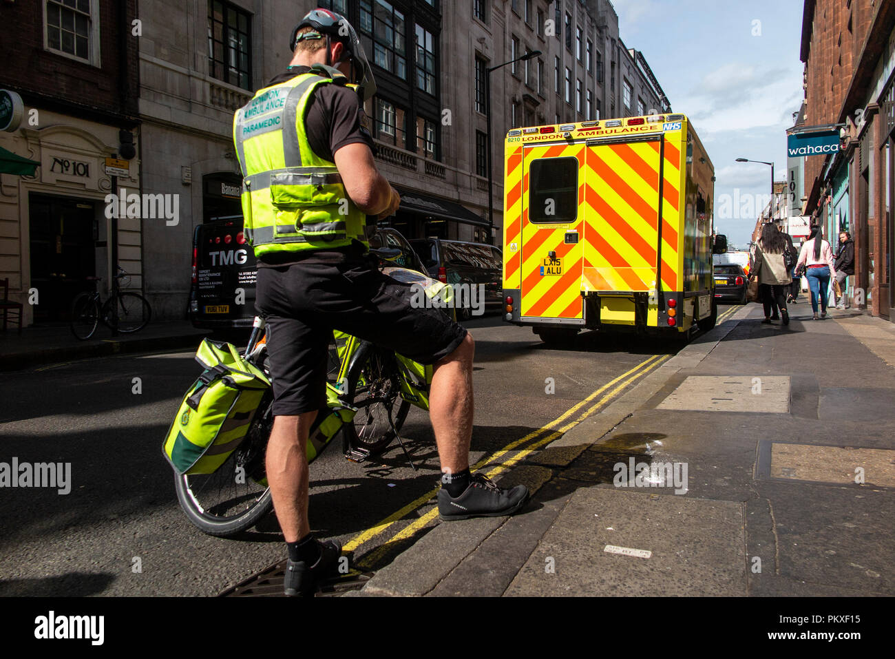 A paramedic with his bike parked behind an ambulance in soho, london ...
