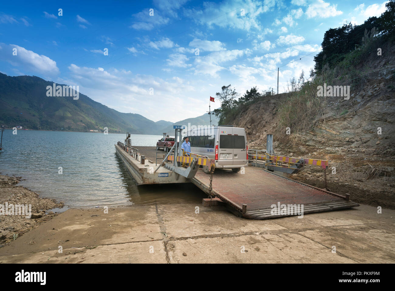 An active ferry carrying cars and passengers passing through the river ...