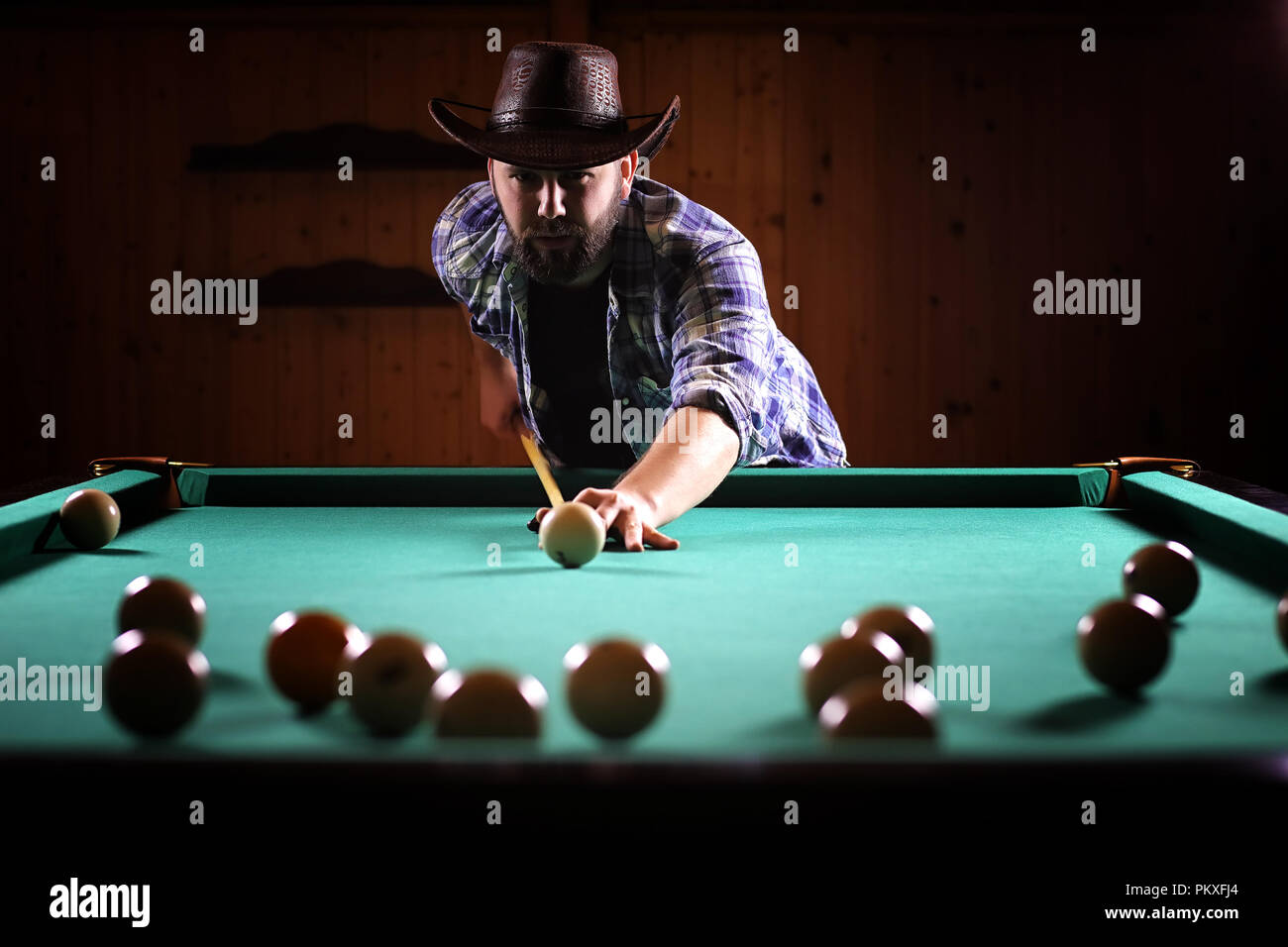 A man with a beard plays a big billiard. Party in a 12-foot pool Stock ...