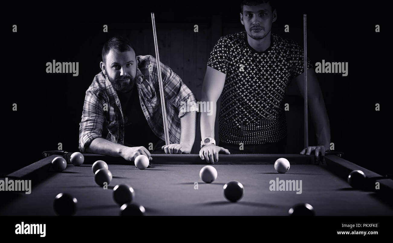 A man with a beard plays a big billiard. Party in a 12-foot pool Stock ...