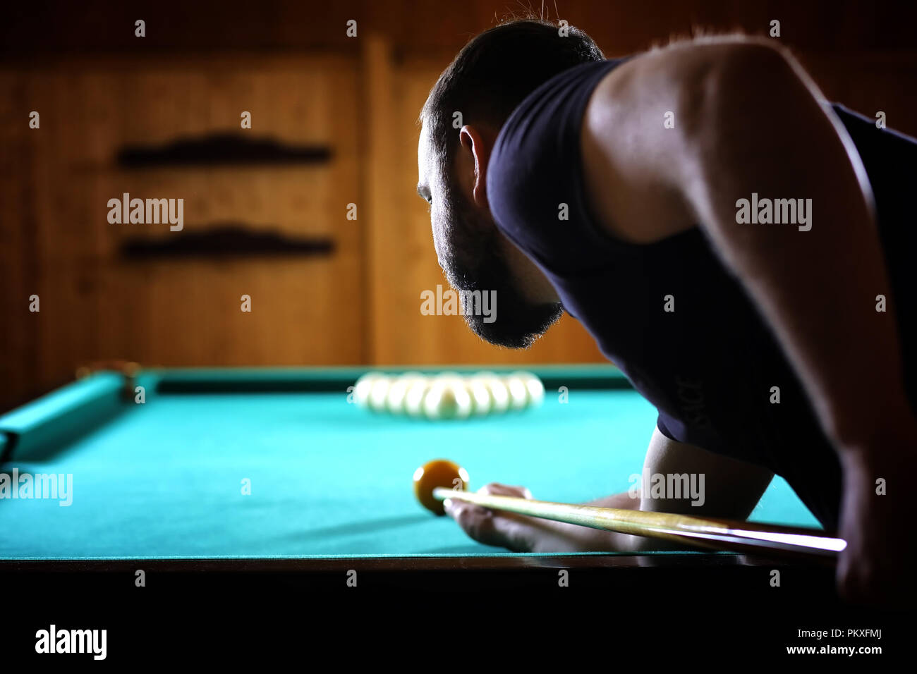 A man with a beard plays a big billiard. Party in a 12-foot pool Stock ...