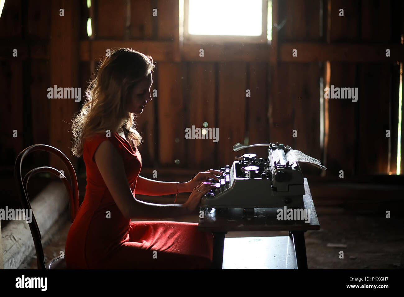 A girl in retro style prints on an old typewriter Stock Photo - Alamy