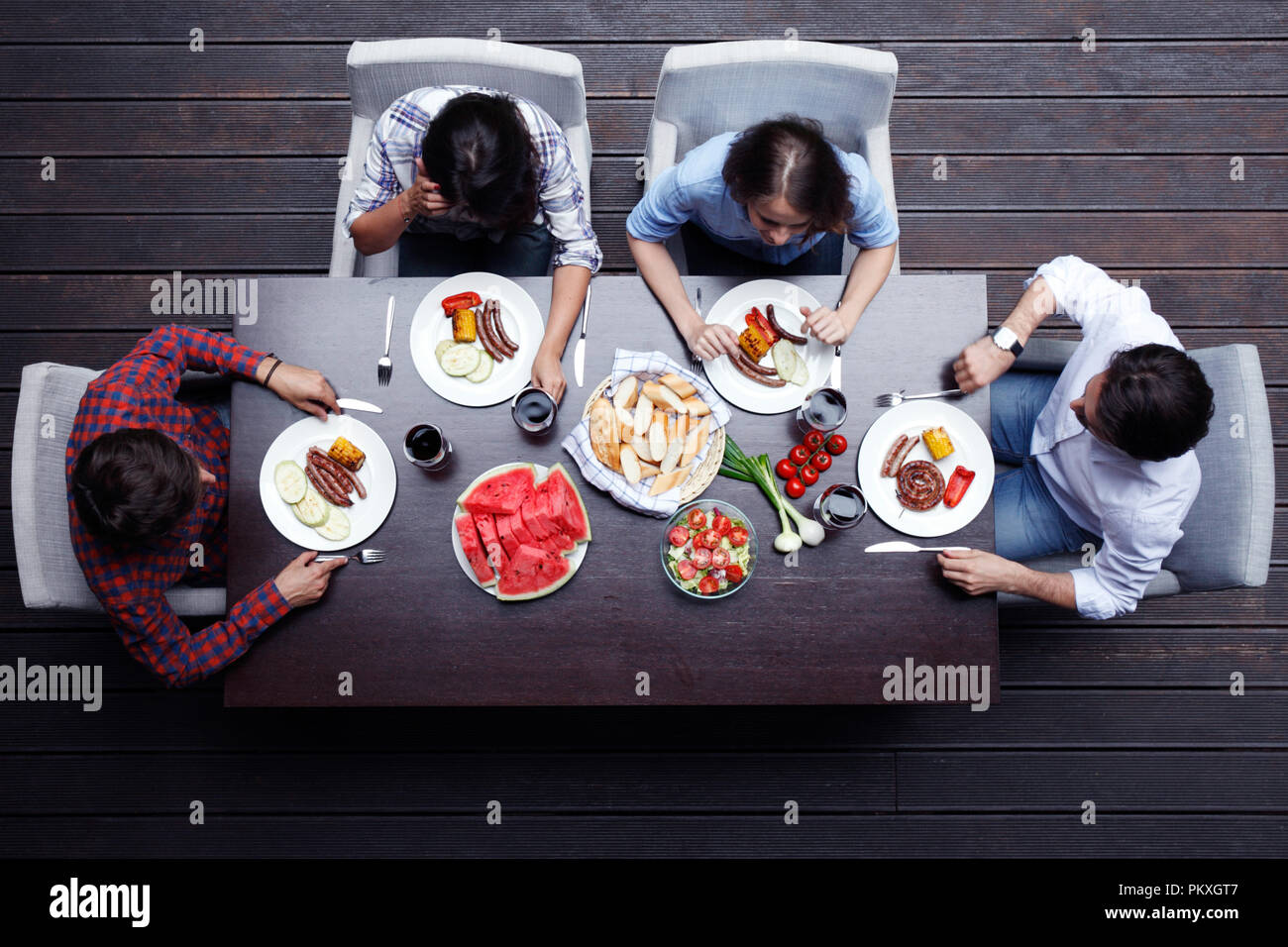 Four friends having dinner, top view Stock Photo - Alamy