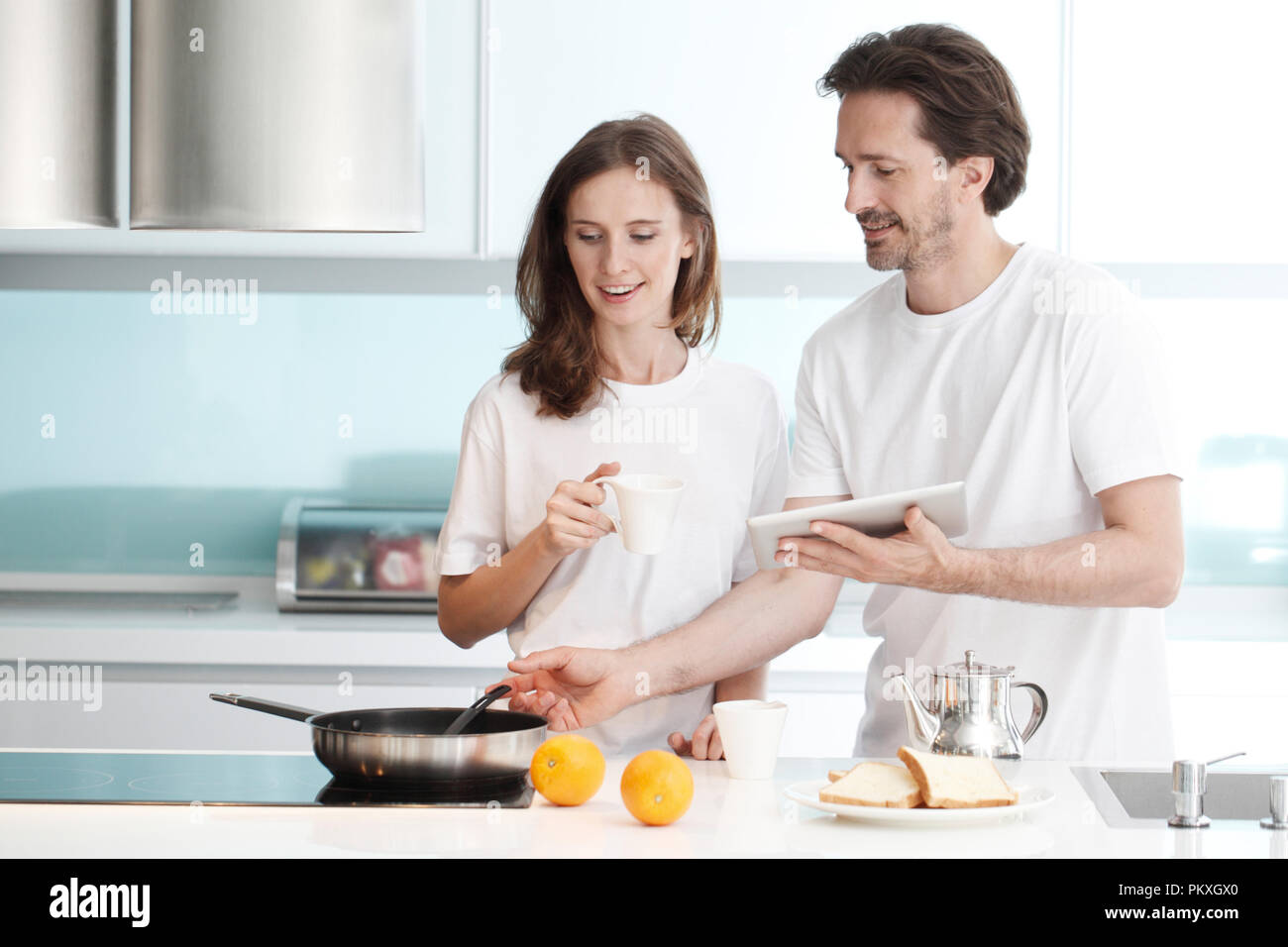 Happy couple cooking breakfast together in the kitchen Stock Photo - Alamy