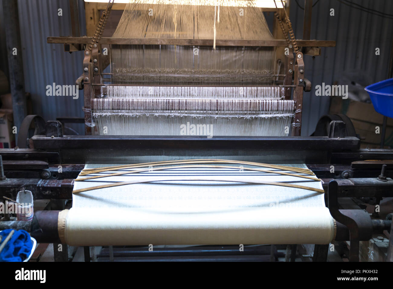 Vietnamese woman operates a silk weaving machine in the silk factory in ...
