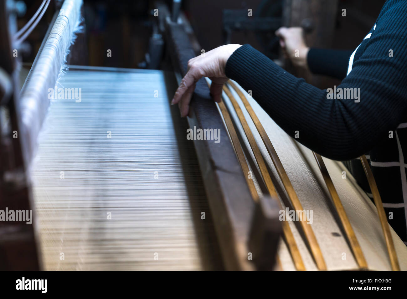 Vietnamese woman operates a silk weaving machine in the silk factory in ...
