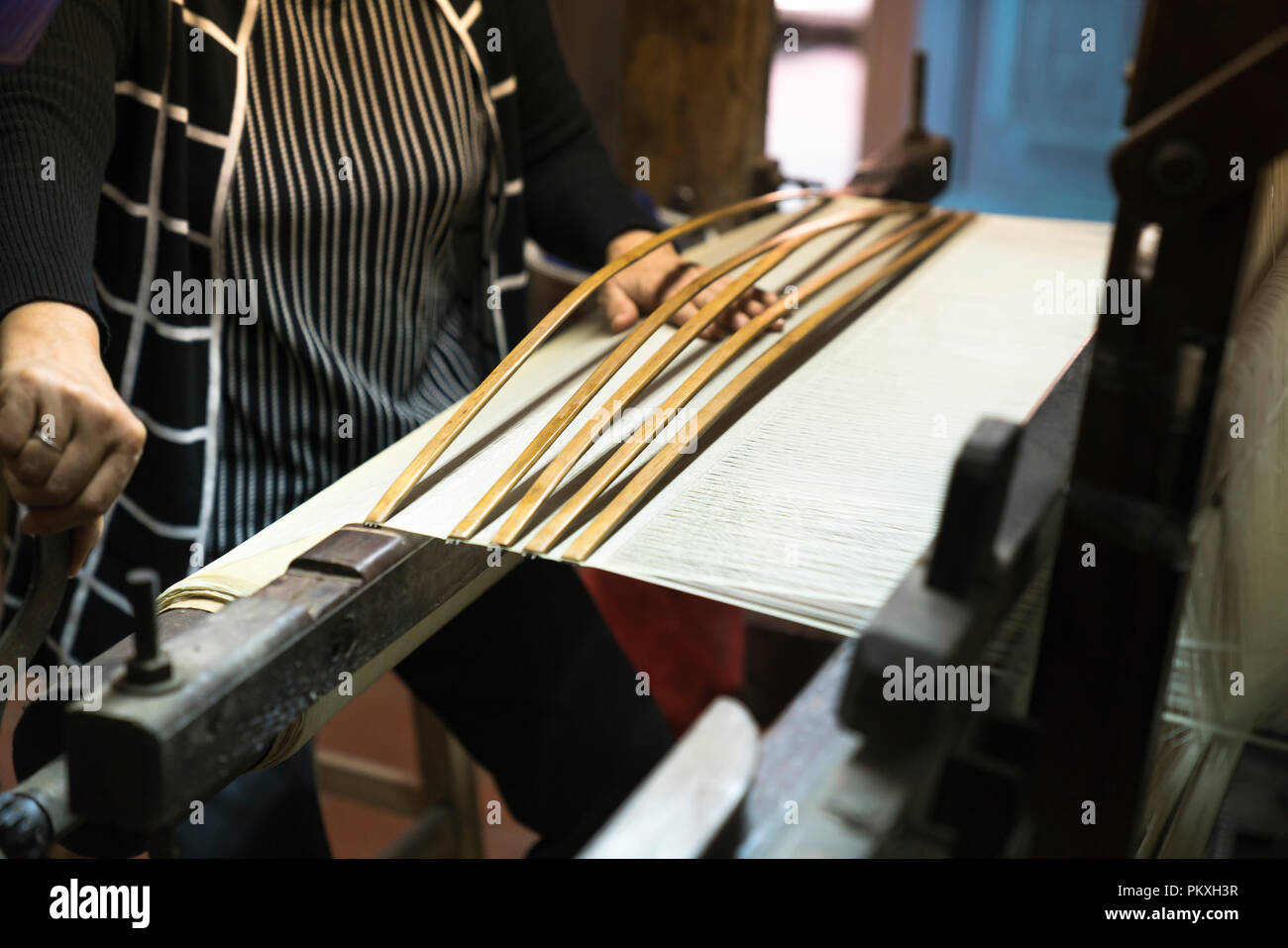 Vietnamese woman operates a silk weaving machine in the silk factory in ...