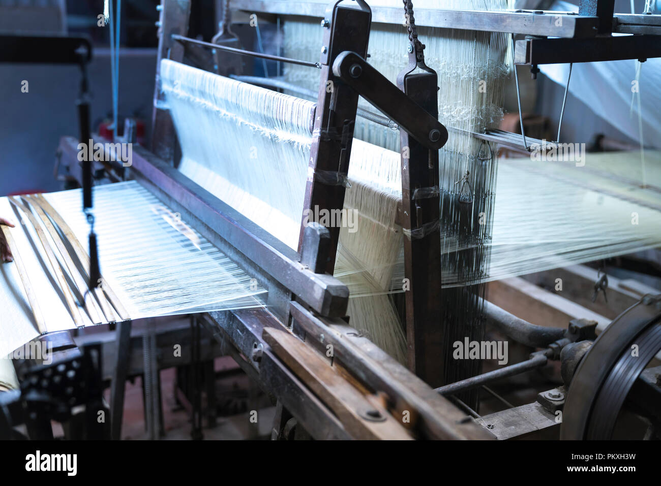 Vietnamese woman operates a silk weaving machine in the silk factory in ...