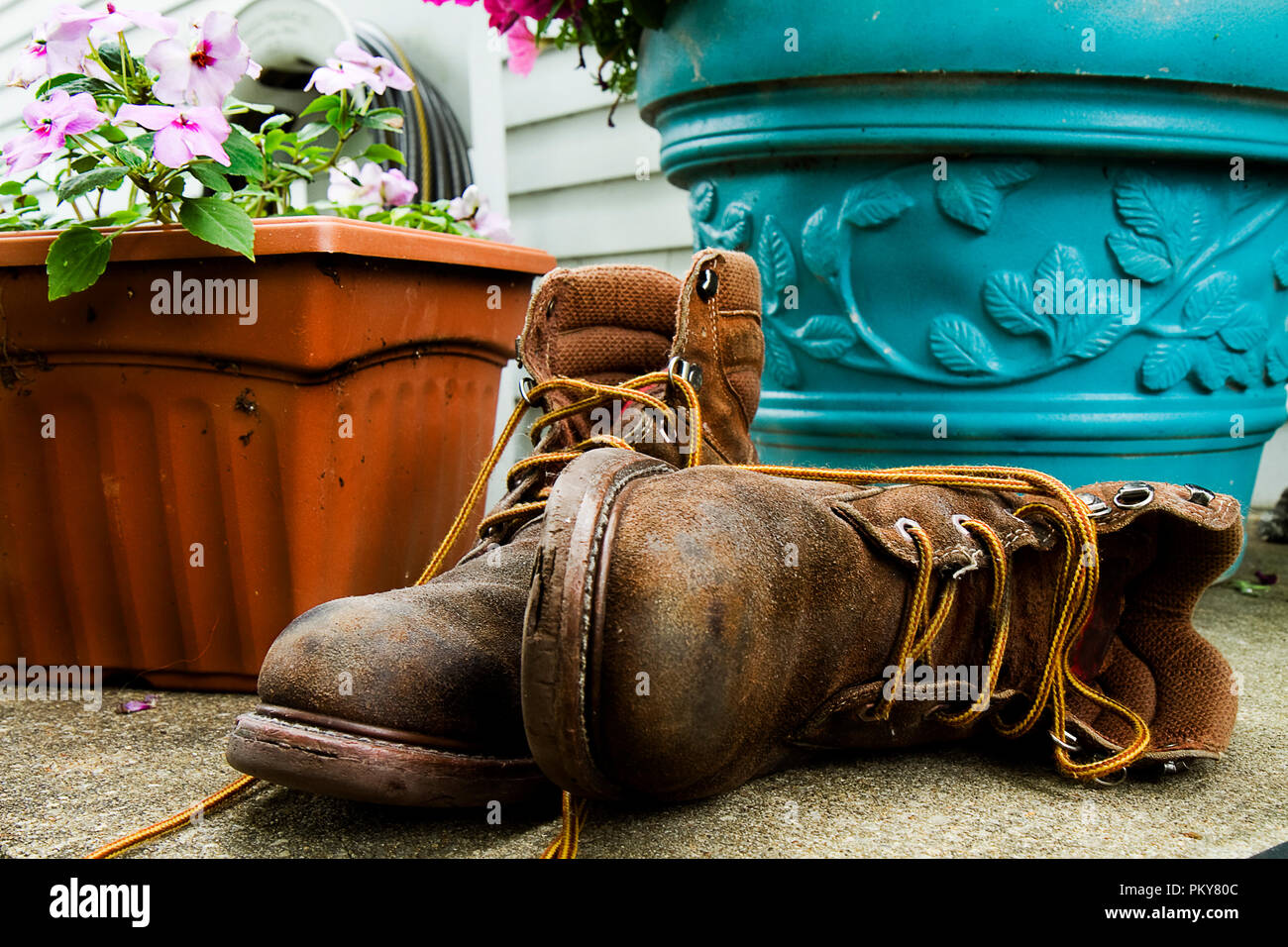 Concept, at the end of the day, weathered and worn men's work boots ...