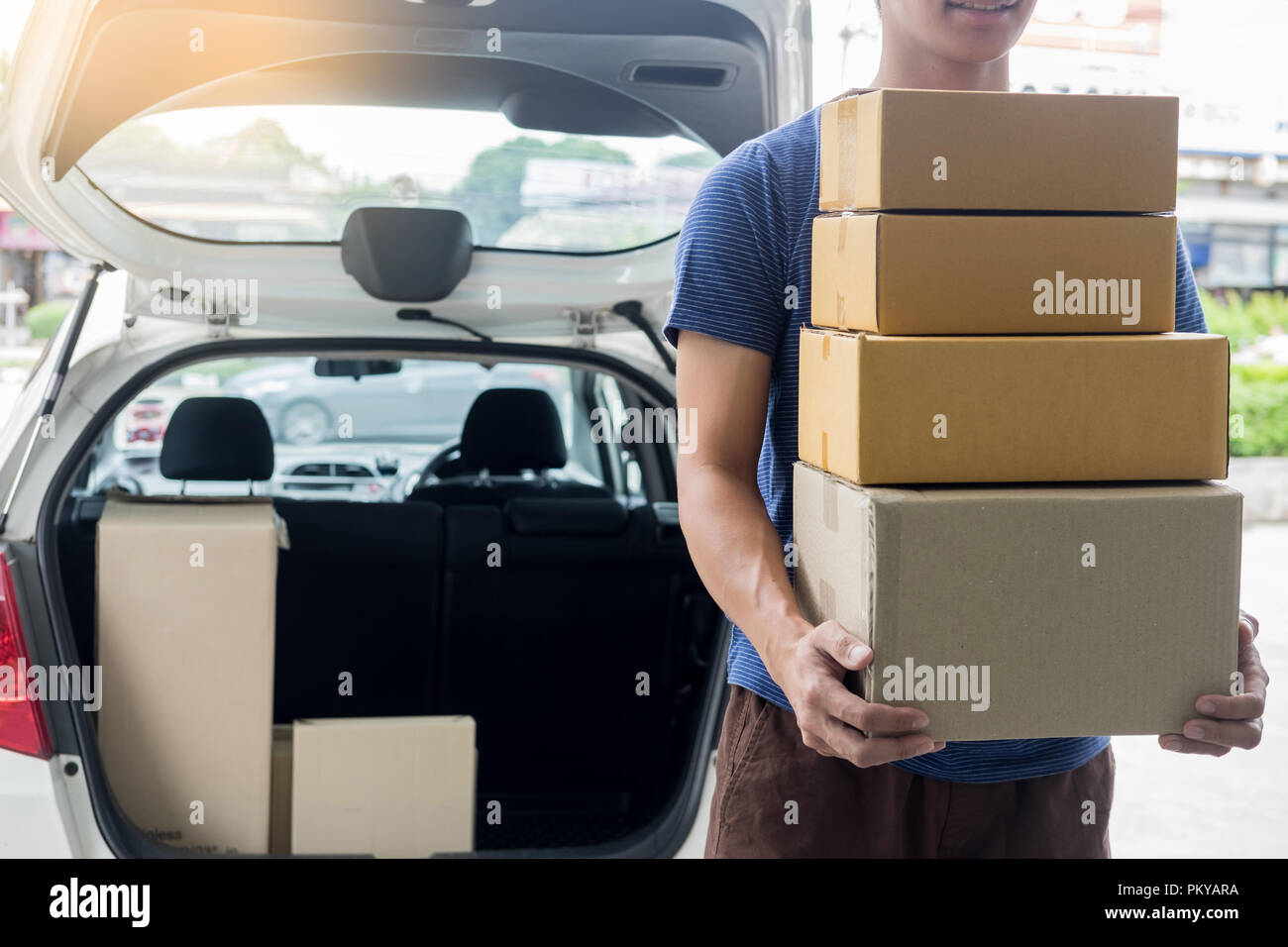 Delivery Loader Postman in blue uniform holding pile of cardboard box ...