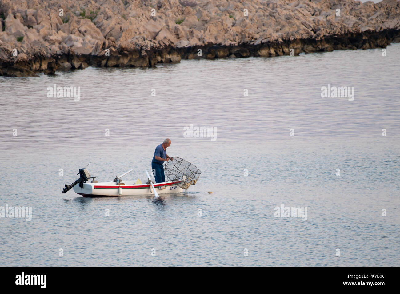 Old traditional fisherman in Croatia on a small wooden boat catching ...