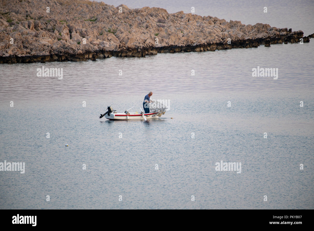 Old traditional fisherman in Croatia on a small wooden boat catching ...