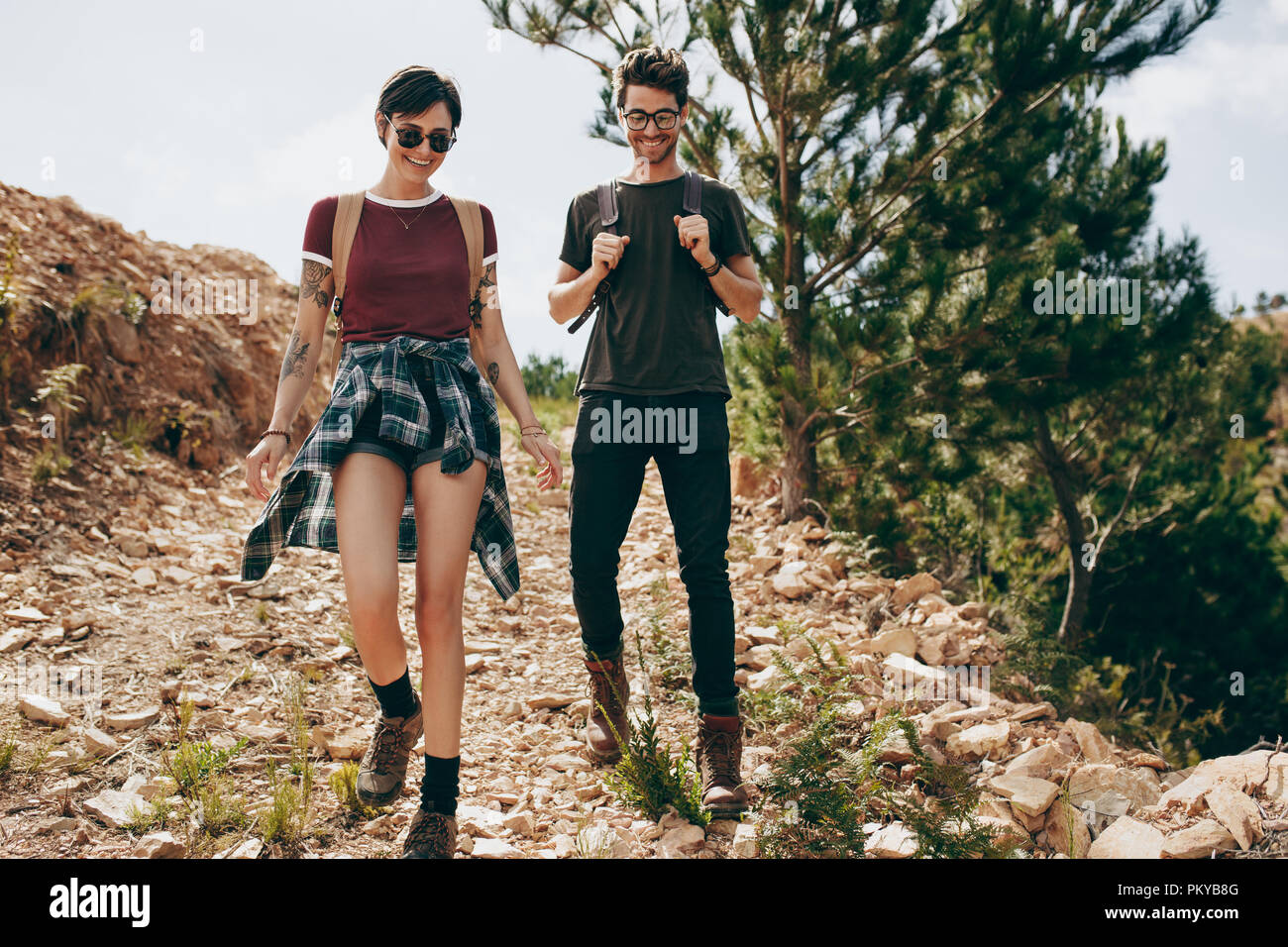 Man And Woman Trekking A Rough Terrain Carrying Backpacks Explorer