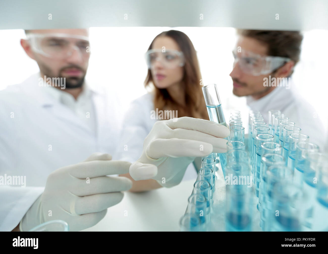 background image is a group of scientists studying the liquid in the ...