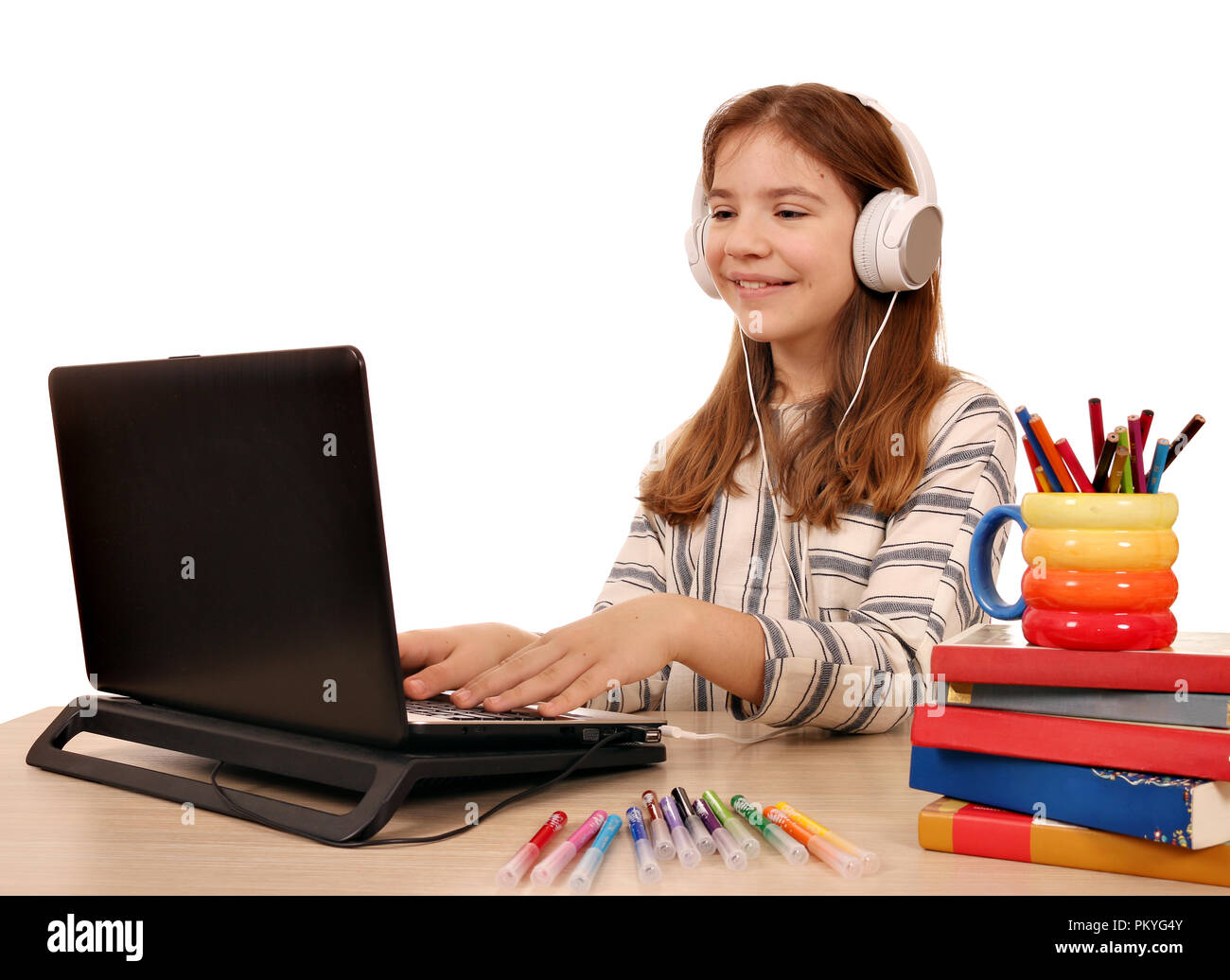 little girl playing laptop and listening music on headphones Stock ...