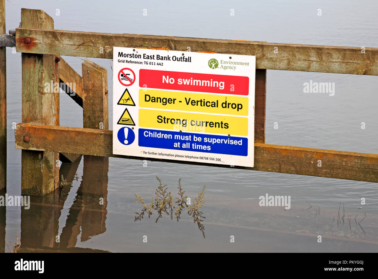 A warning sign by the Norfolk Coast Path by salt marshes at Morston ...