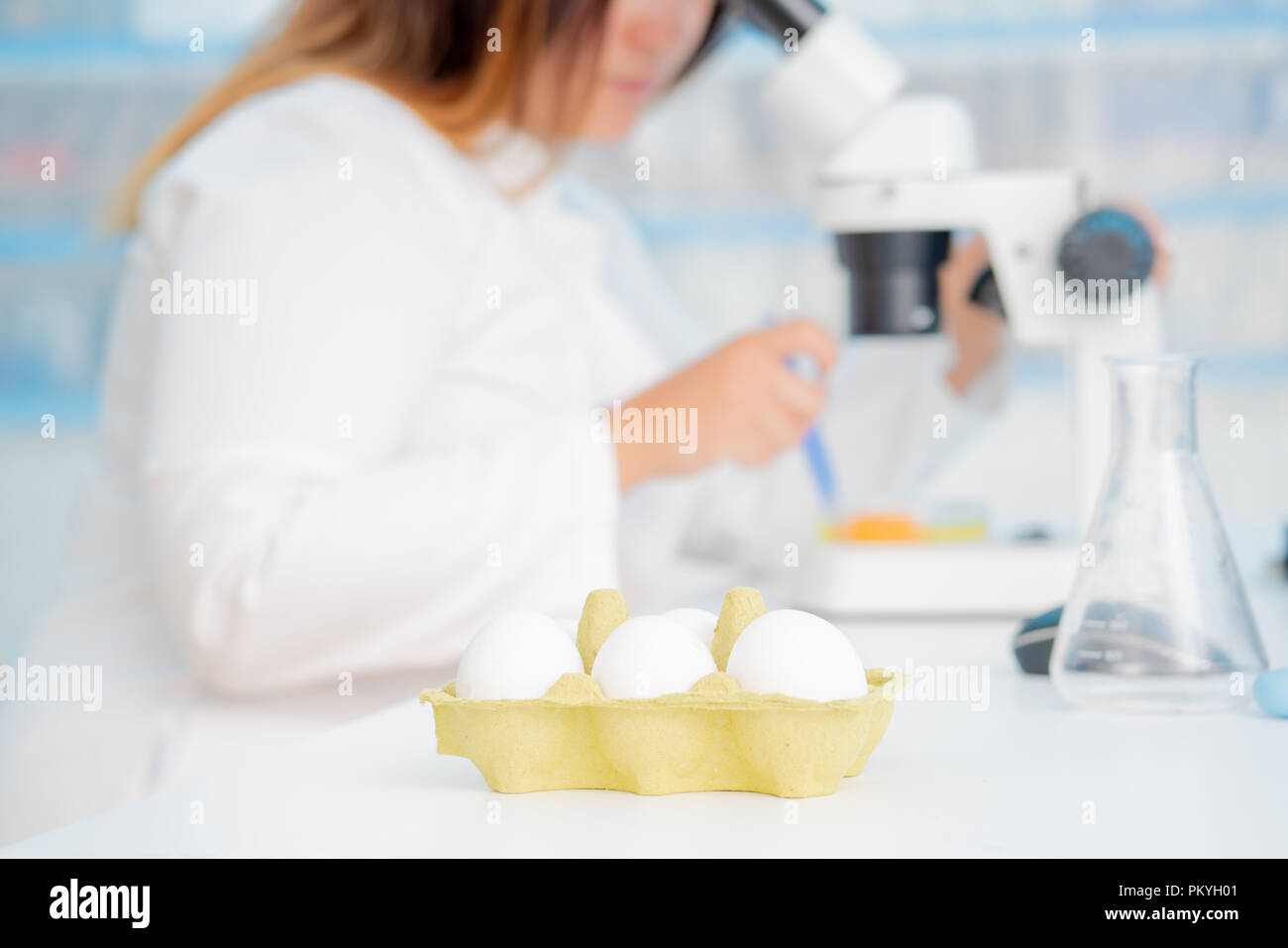 Quality control expert inspecting at chicken eggs in the laboratory ...