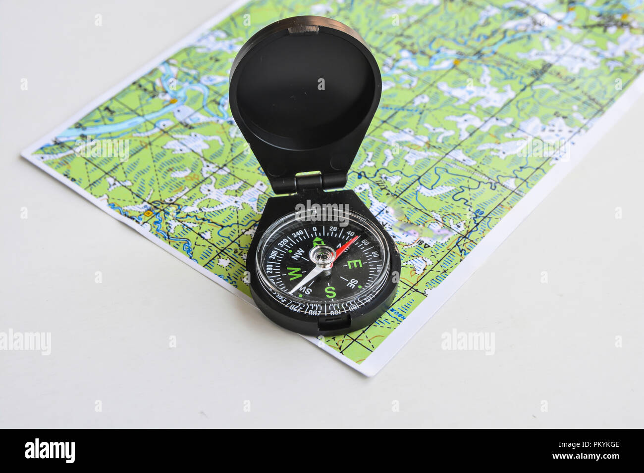 Compass and map. The magnetic compass is located on a topographic map ...