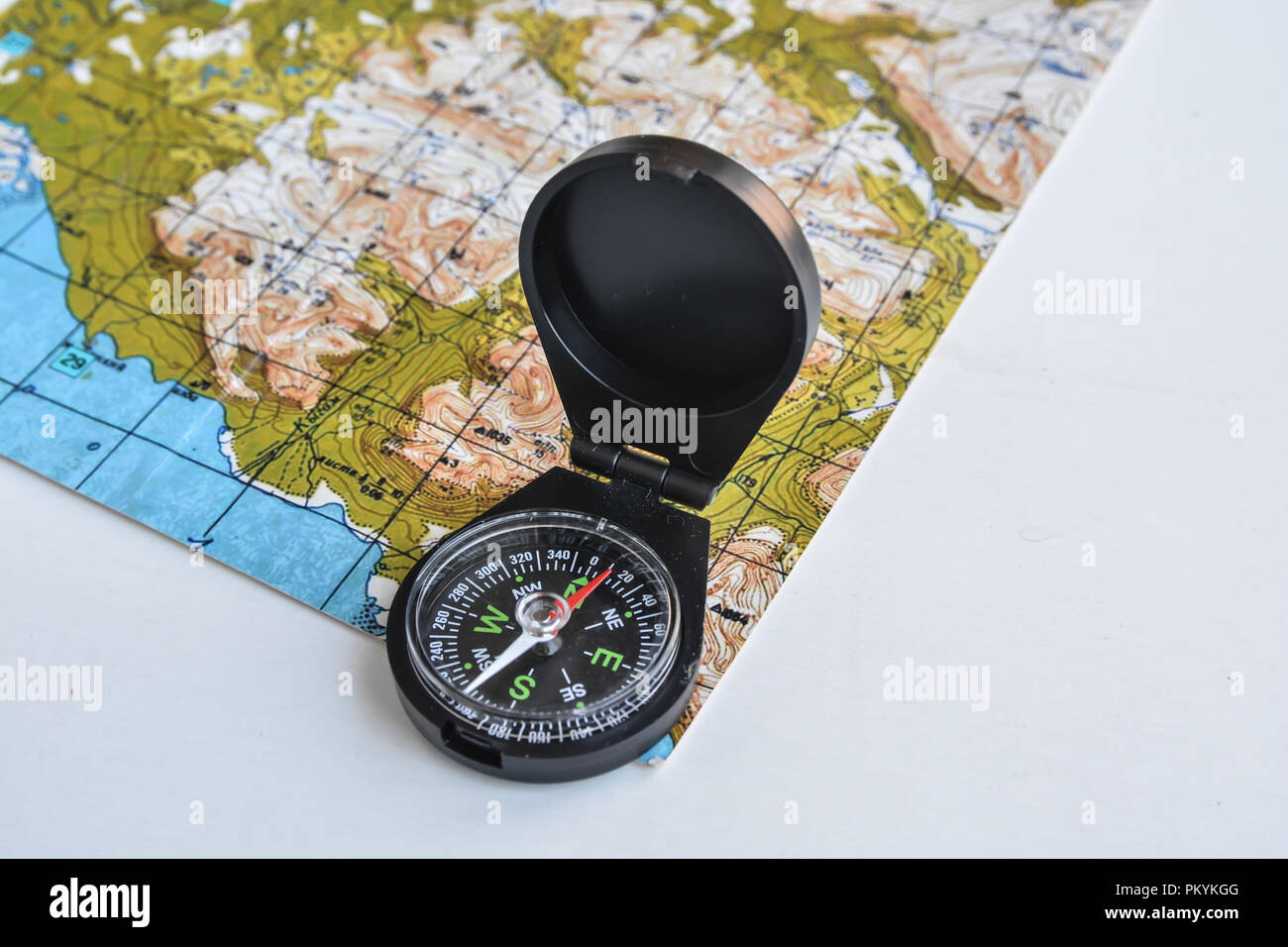 Compass and map. The magnetic compass is located on a topographic map ...