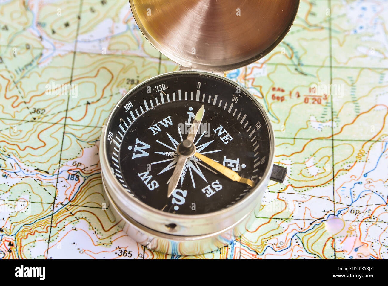 Compass and map. The magnetic compass is located on a topographic map ...