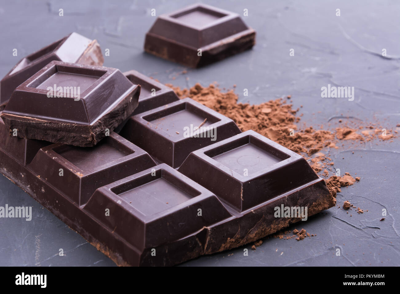 Broken chocolate bar slice on grey background Stock Photo - Alamy