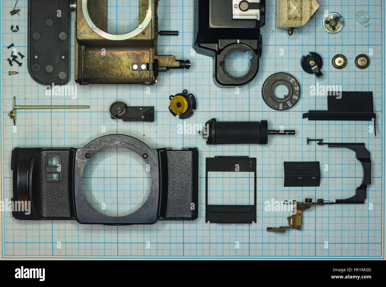 parts are completely disassembled old retro film SLR camera on graph ...