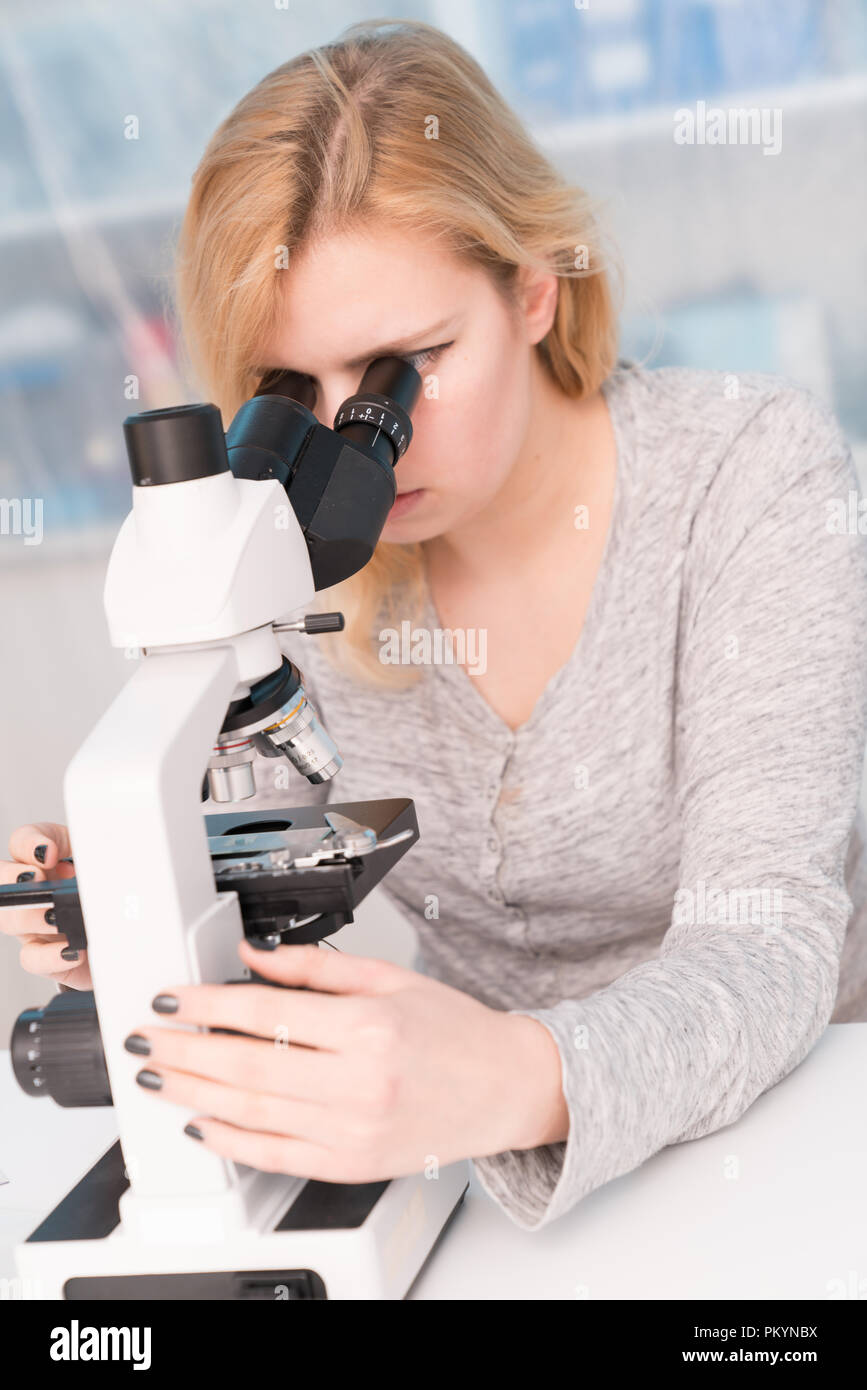 Young woman work with microscope in lab Stock Photo - Alamy