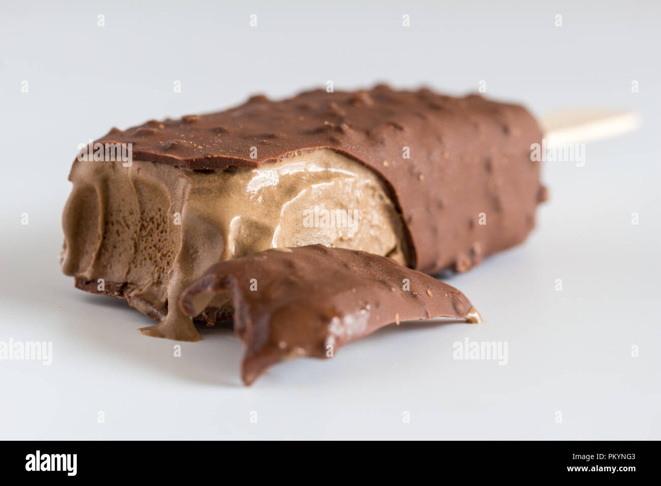 Chocolate ice cream on stick with selective focus on bitten front part ...