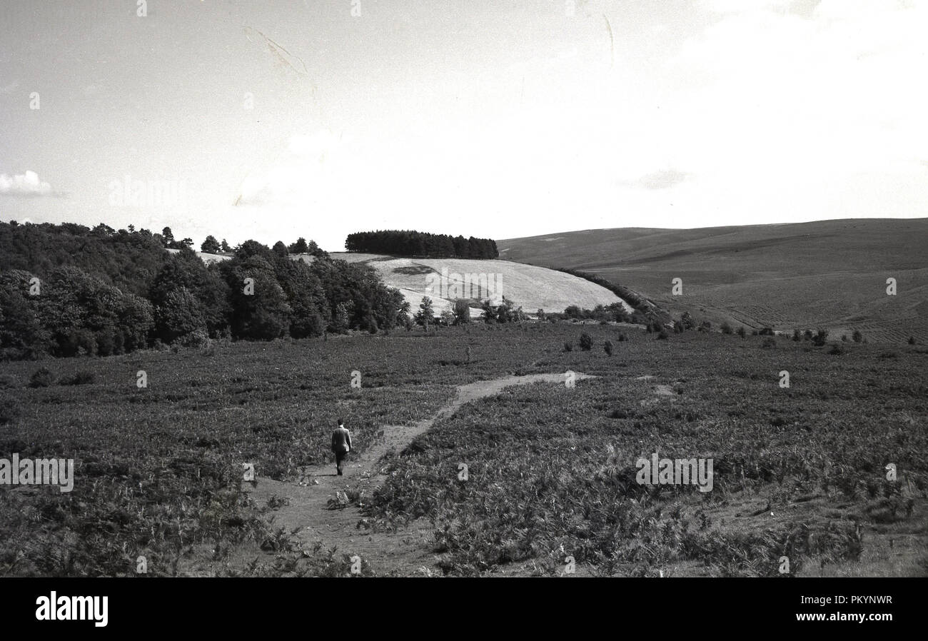 1950, gentleman walking along a footpath outside in the open ...