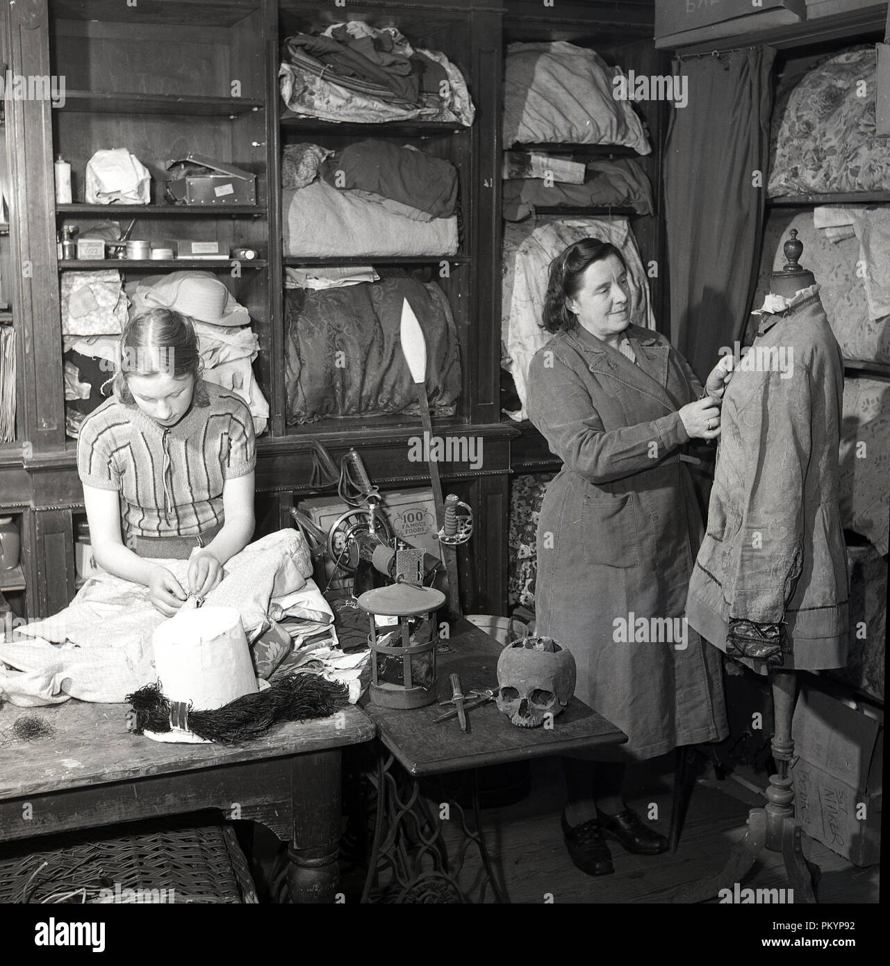 1950s, historical, a lady and a young woman working in a costume store ...