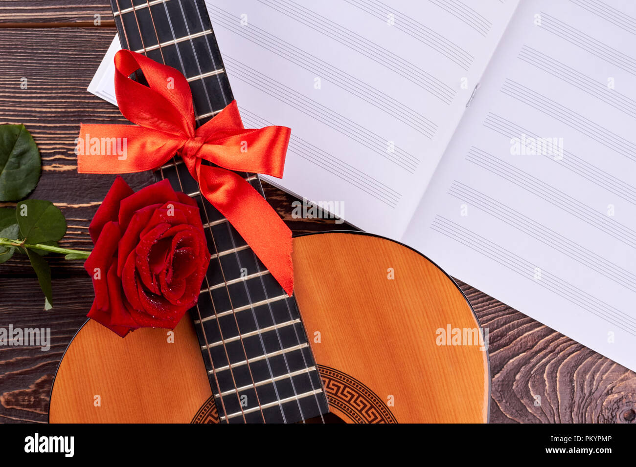 Guitar and musical notes on wooden background. Retro guitar with red ...