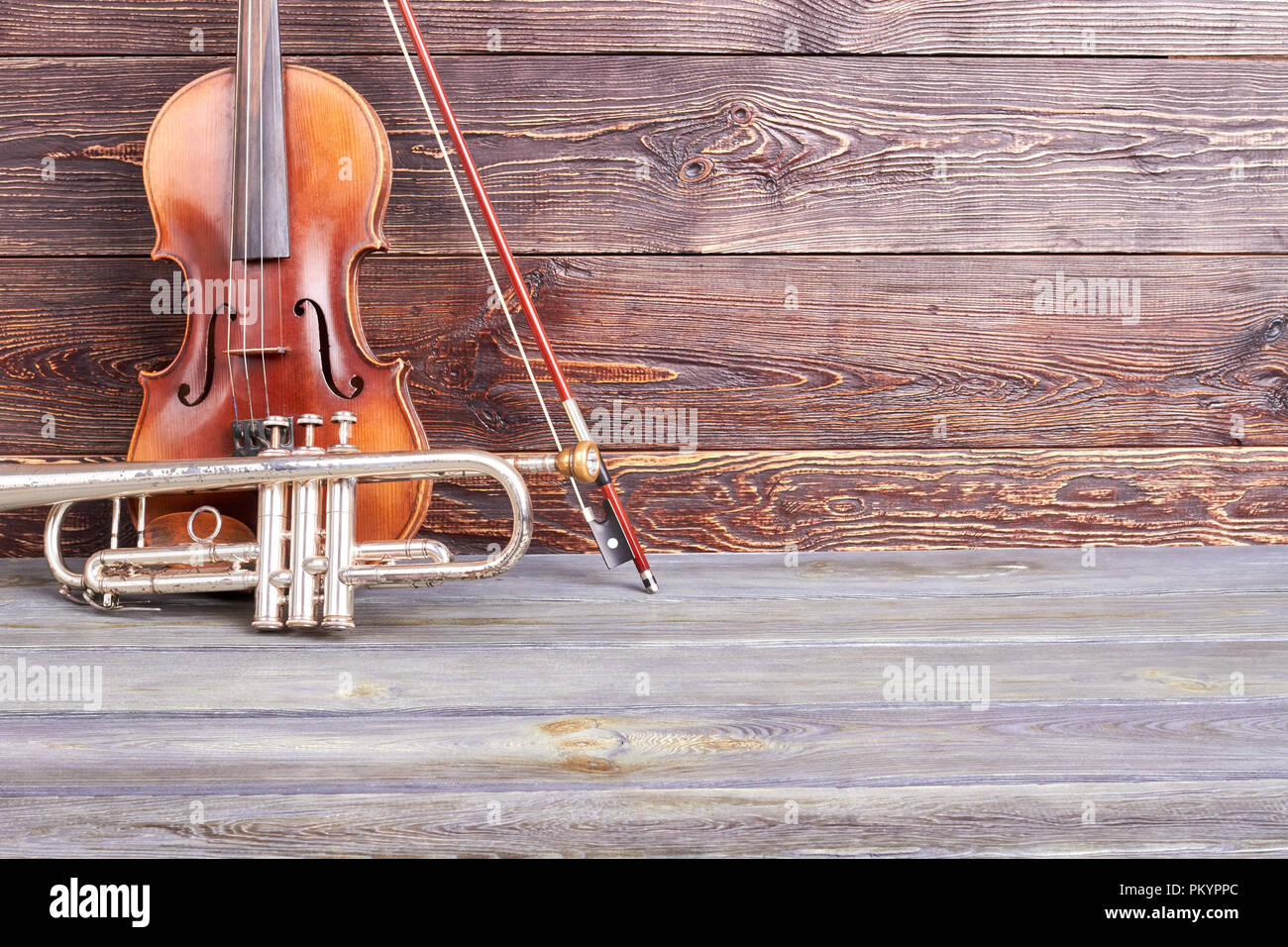 Aged violin and trumpet on wooden background. Old musical instruments ...