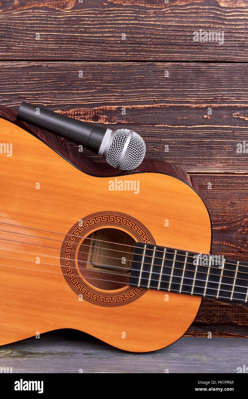 Guitar and microphone on wooden background. Microphone on acoustic ...