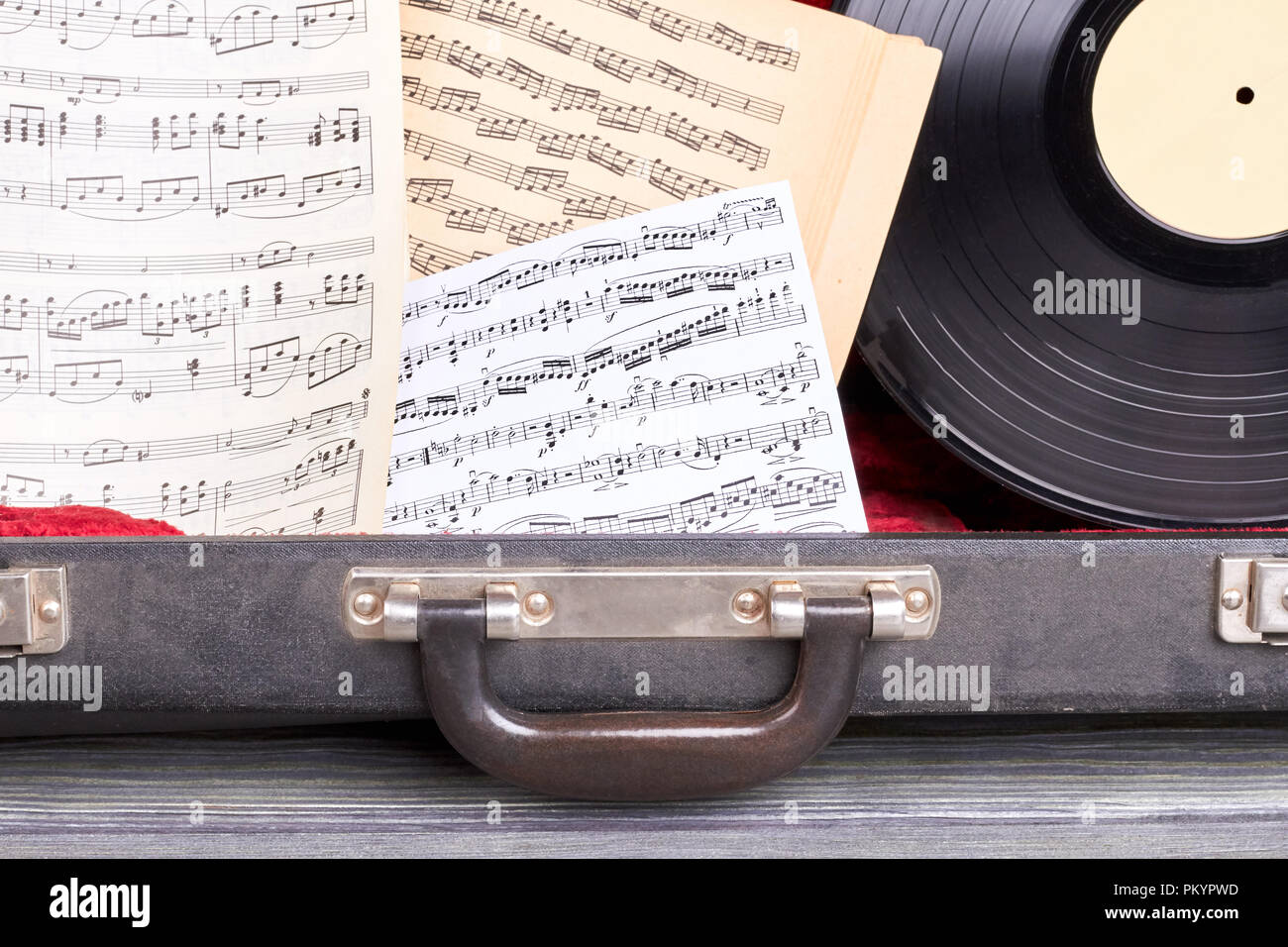 Close up musical notes and vinyl record. Case with musical notes sheets ...