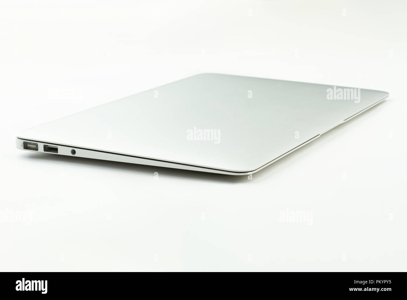 Closed laptop on white desktop. Silver notebook on light surface ...