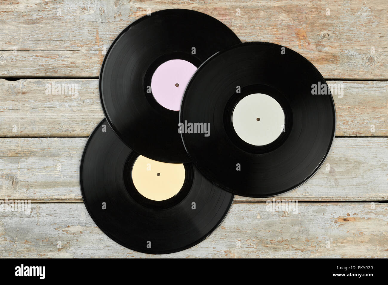 Three vinyl records with different labels. Set of vinyl discs on wooden ...