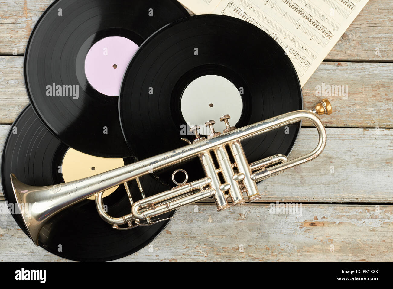 Vinyl records and trumpet on wooden background. Set of musical ...