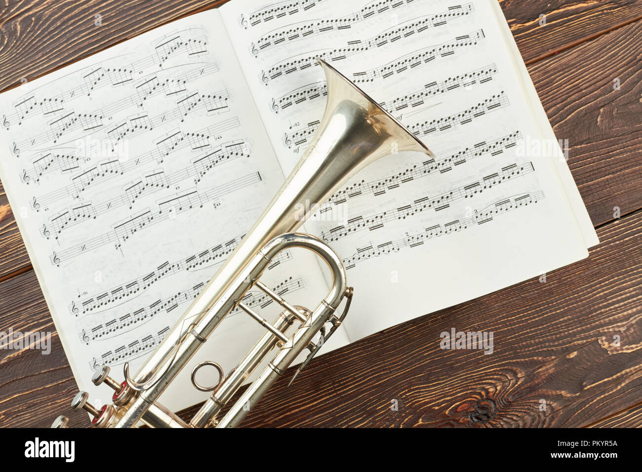 Trumpet on musical notes book. Pipe and musical notes on wooden ...