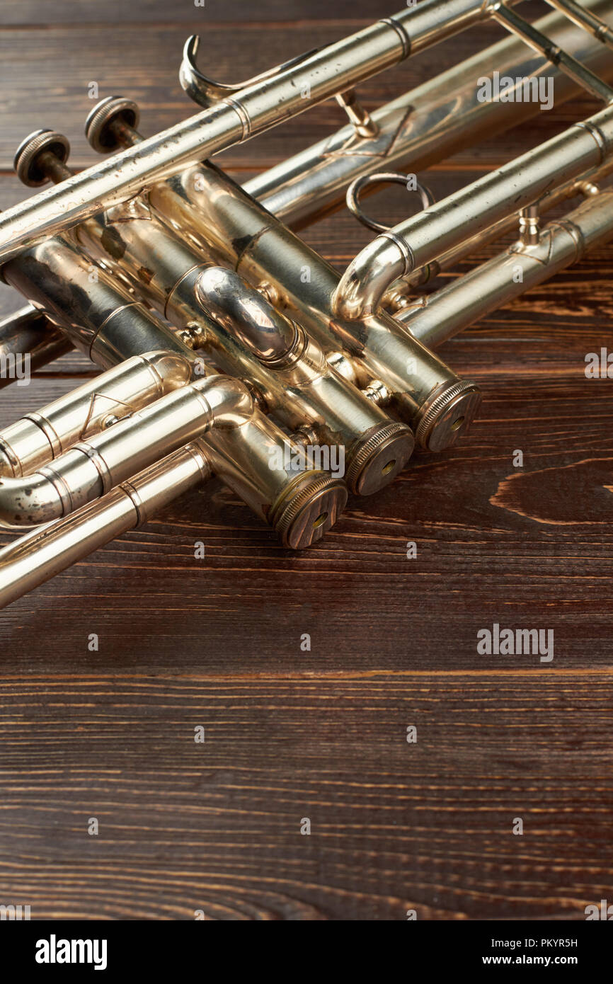 Detail of old trumpet instrument. Close up trumpet on wooden background ...