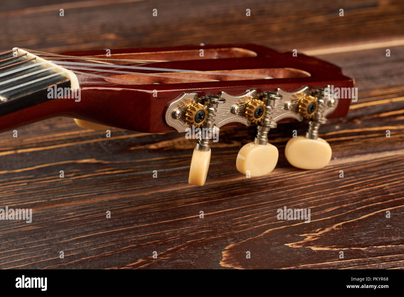 Head of acoustic guitar on wooden background. Head neck of classical ...