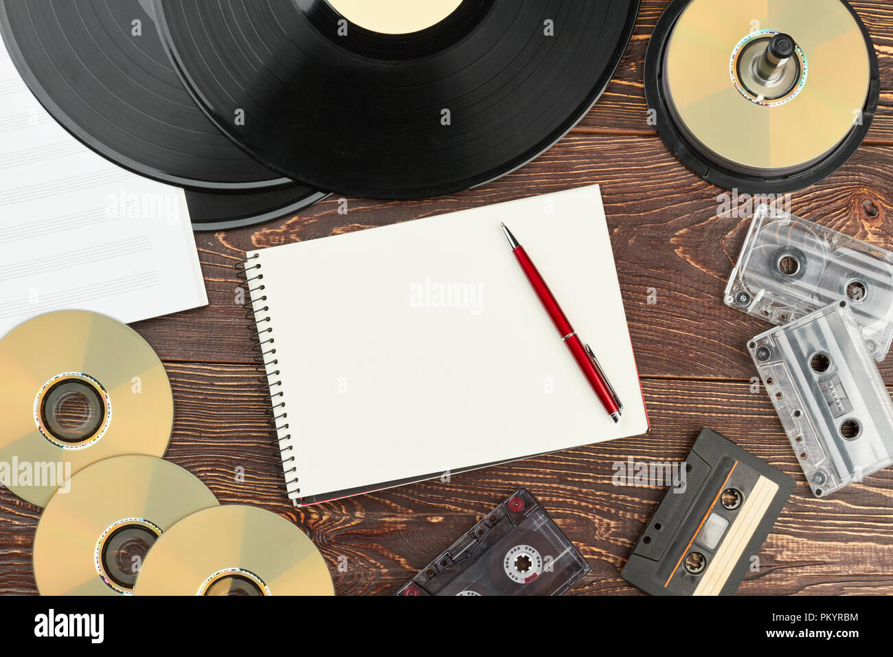 Retro audio devices and blank notebook. Work space with vinyl records ...
