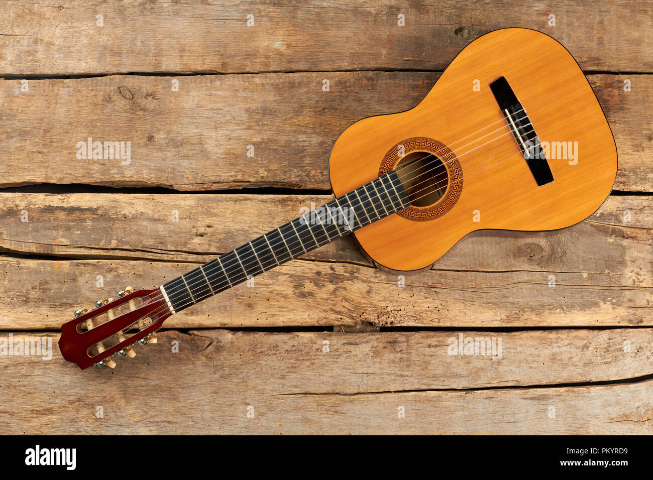 Yellow wooden acoustic guitar. Six strings acoustic guitar on rustic ...