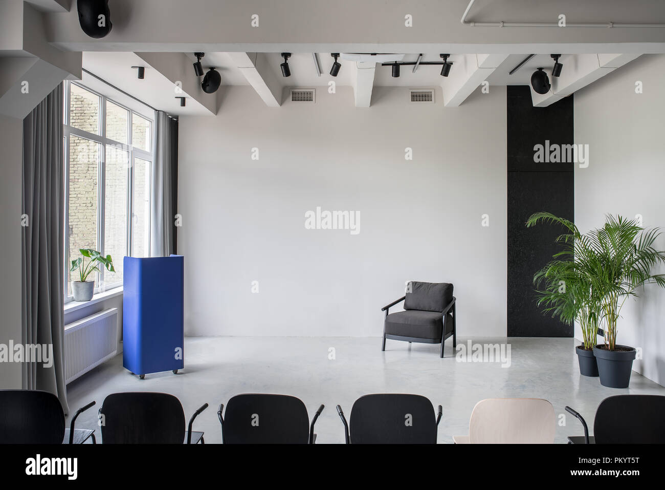 Stylish conference hall with gray walls and a glossy floor. There is a ...