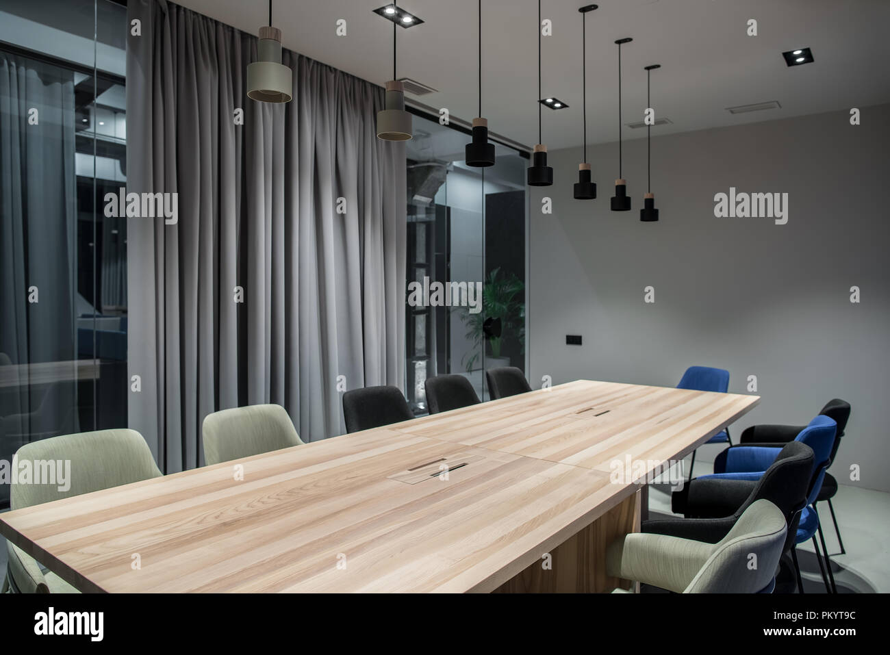Meeting room with a luminous lamps in an office with gray walls. There ...