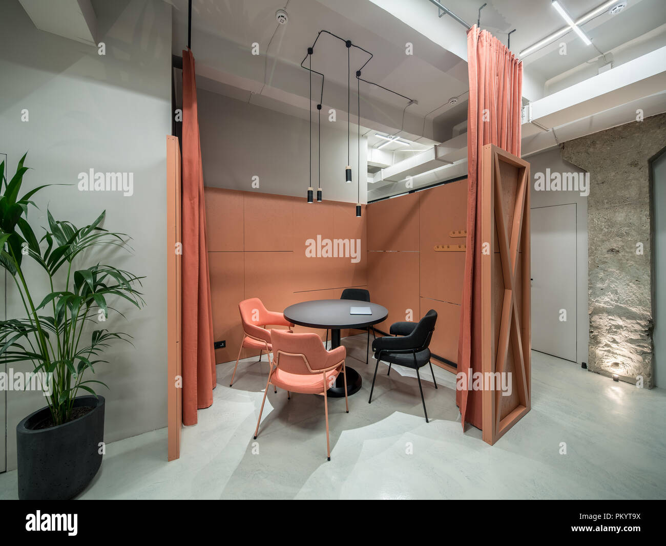 Discussion zone with orange curtains in a luminous office with gray ...