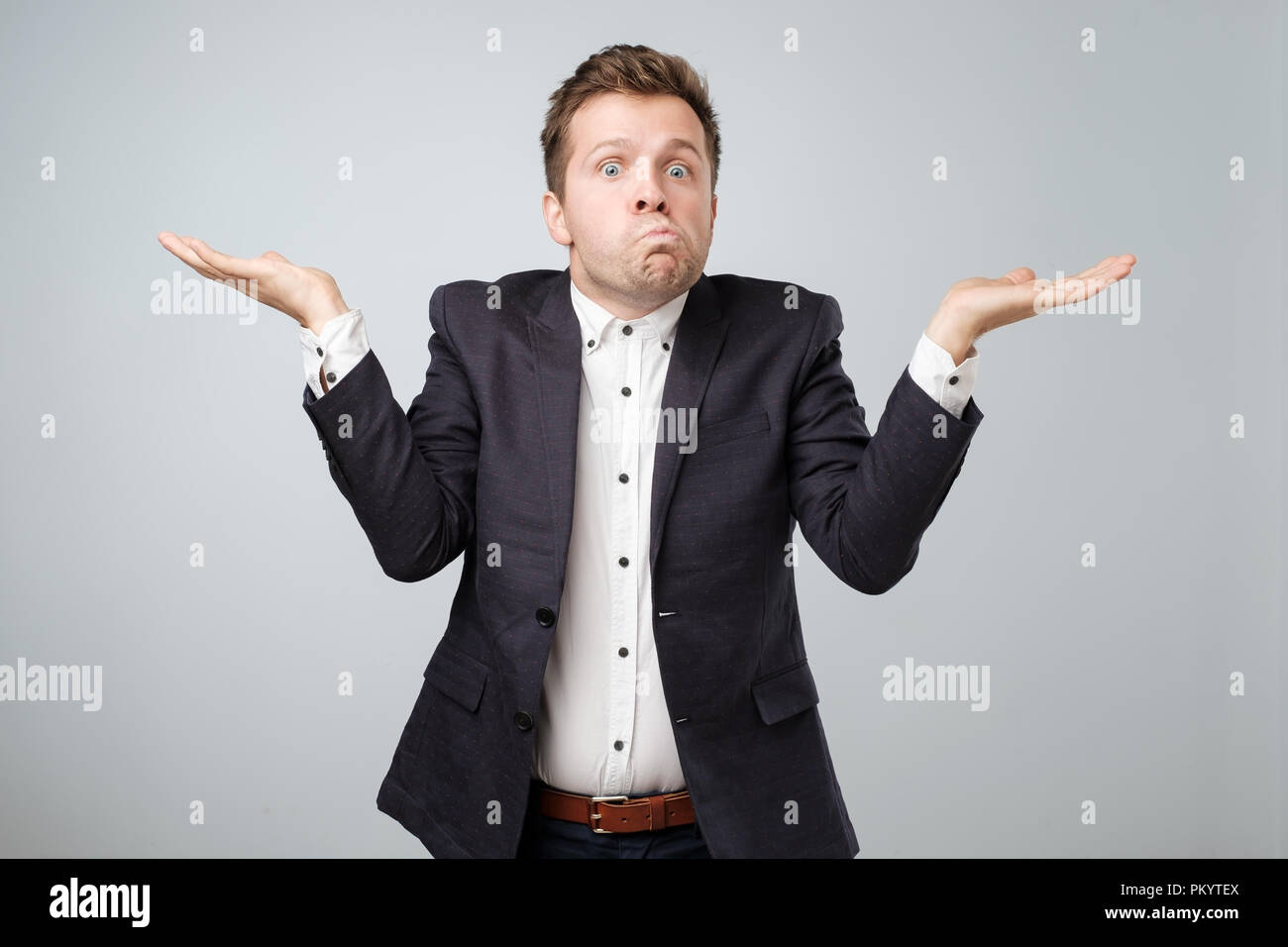 Young caucasian man in suit and white shirt is confused Stock Photo - Alamy