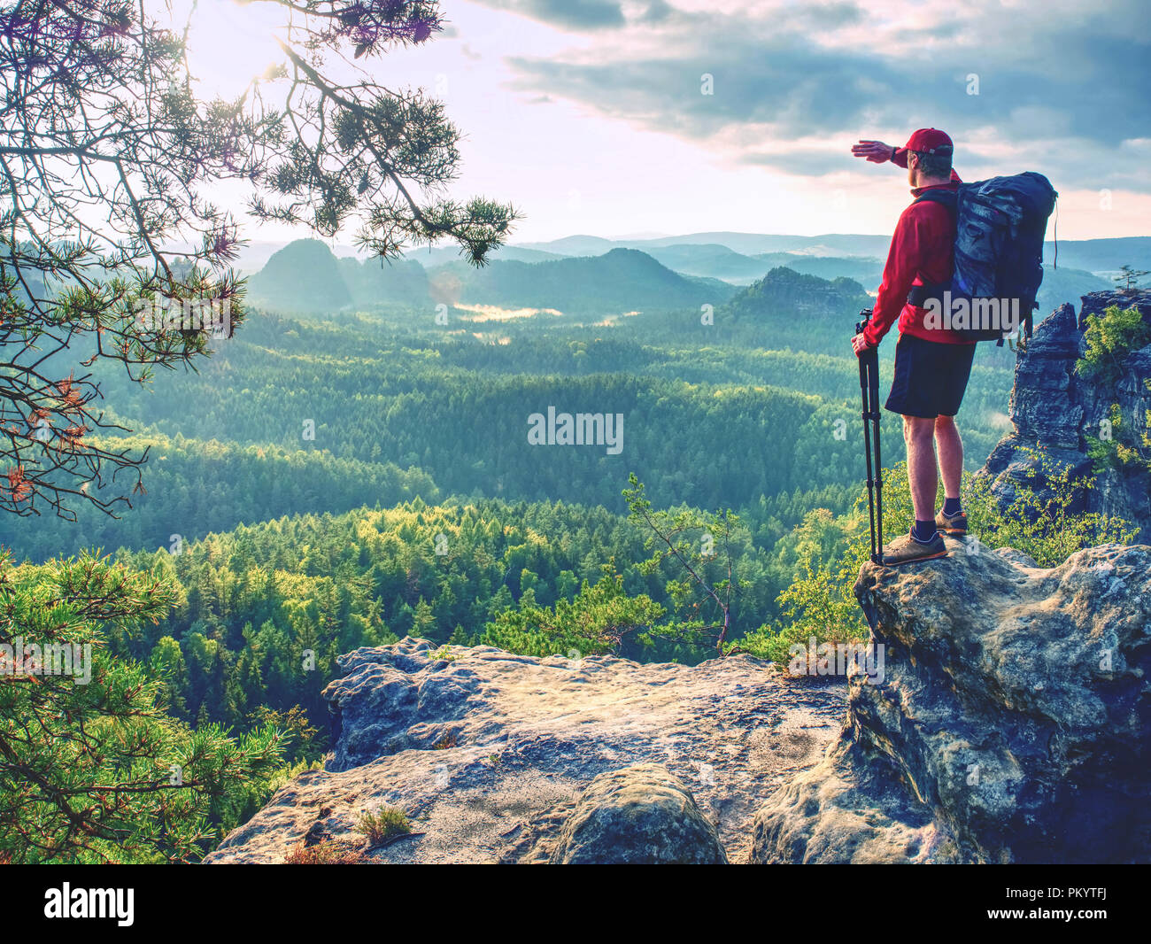 Tall photographer with heavy backpack and tripod in hands stand on ...