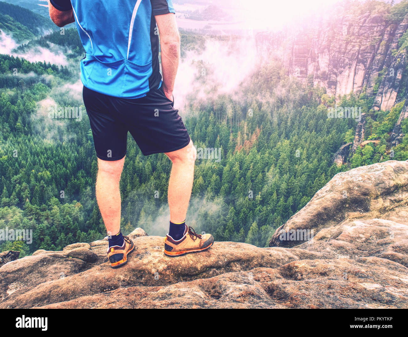 Hiker legs climbing on sunrise mountain peak rock. Slim legs of a ...